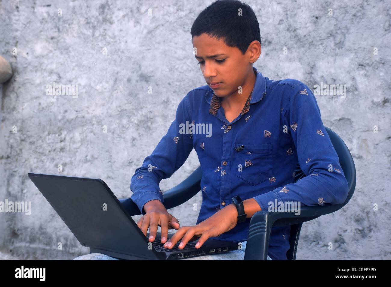 Teen handsome student using laptop. Cheerful boy studying online on ...