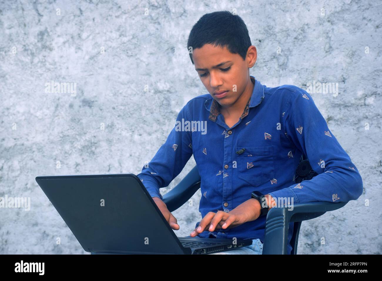 Teen handsome student using laptop. Cheerful boy studying online on ...