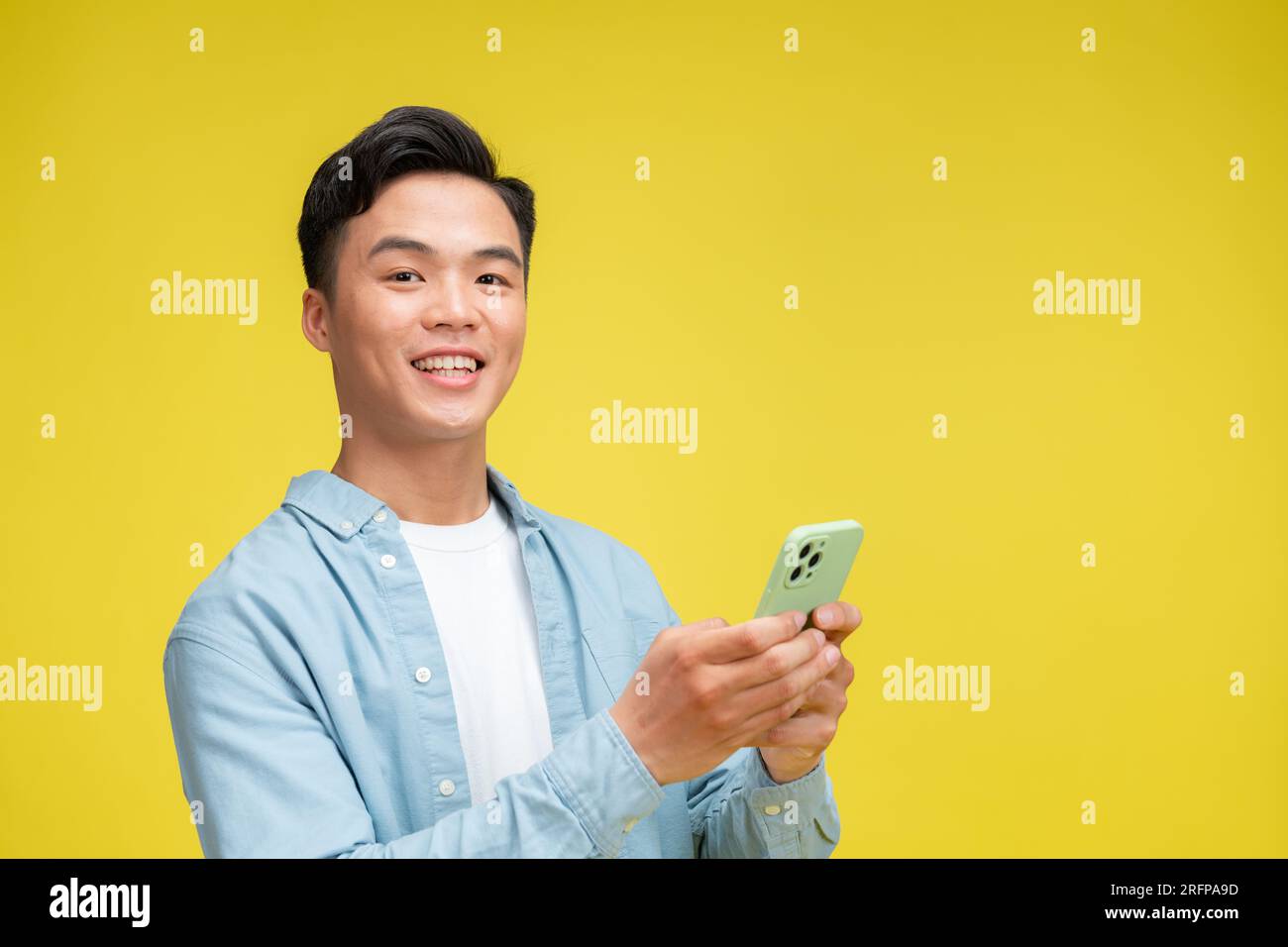 Young man holding a mobile phone, receiving a pleasant surprise ...