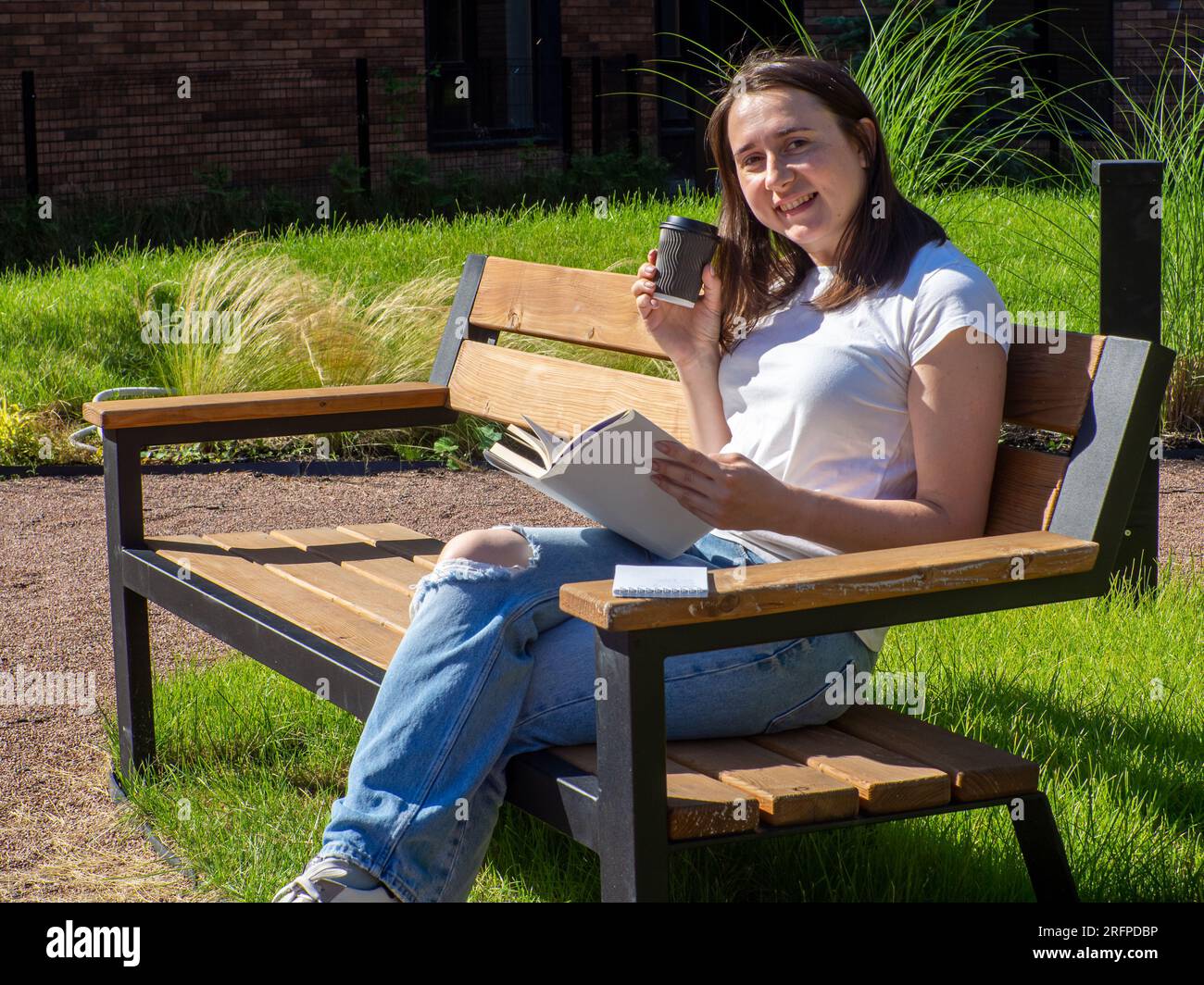 Female student studying on bench at campus Stock Photo - Alamy