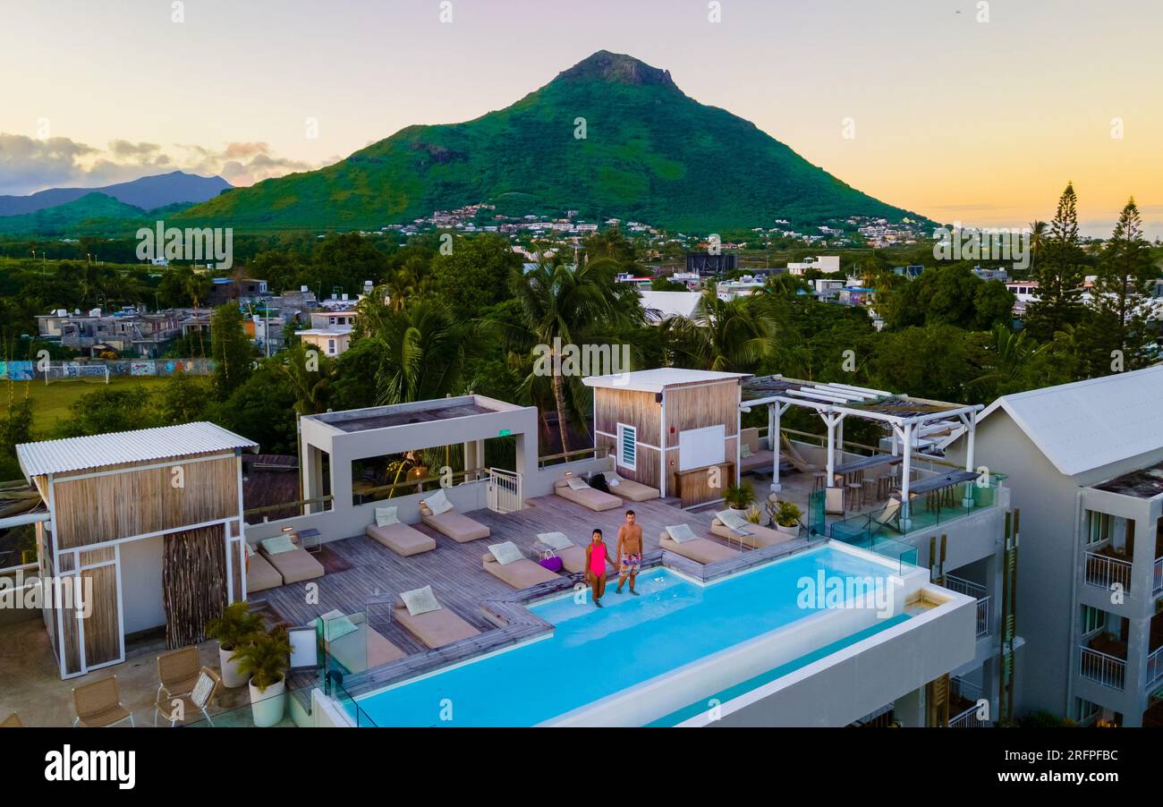 Man and Woman relaxing in a swimming pool watching sunset, a couple on ...