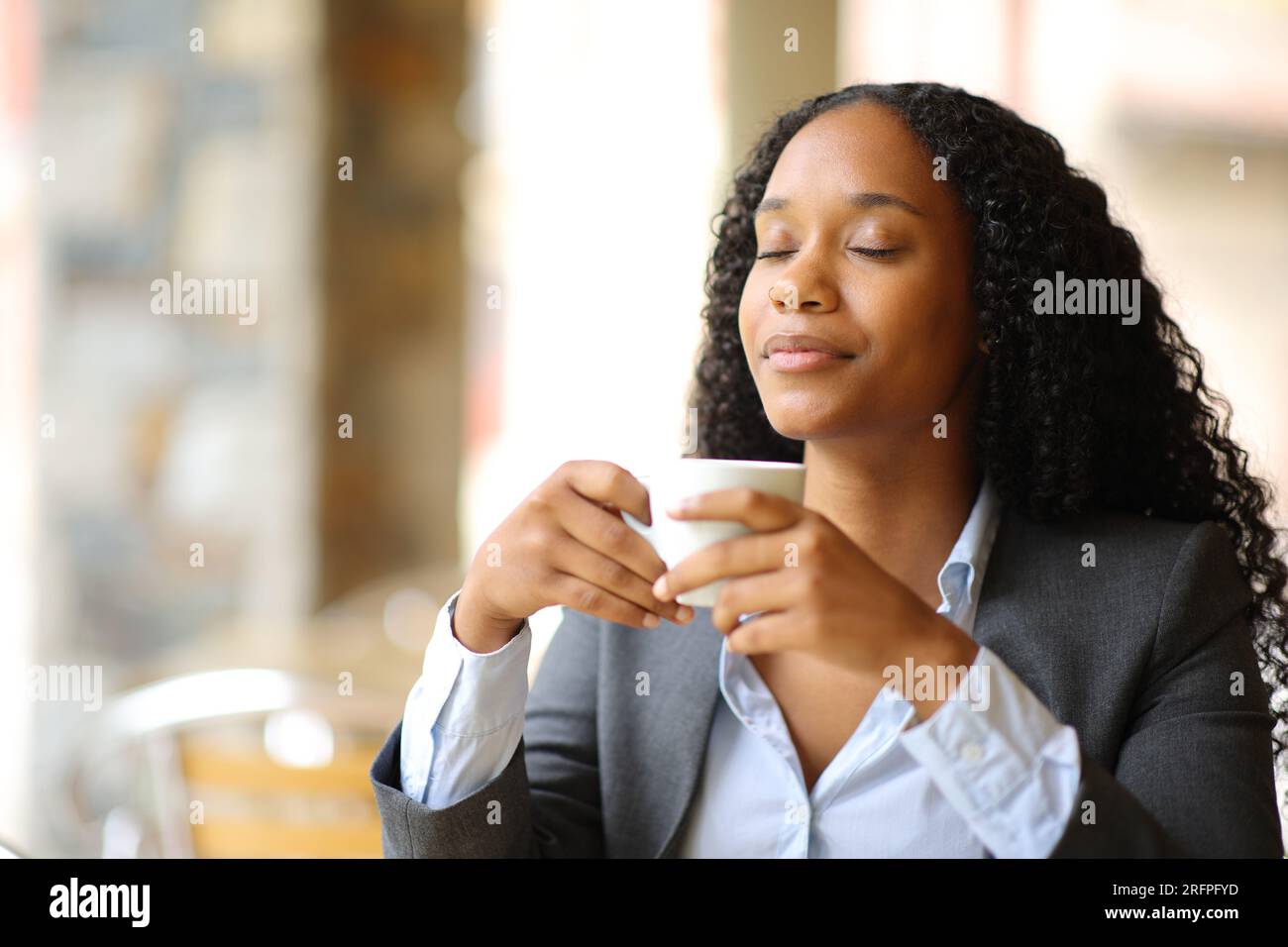Executive relaxing drinking and breathing in a coffee shop terrace ...