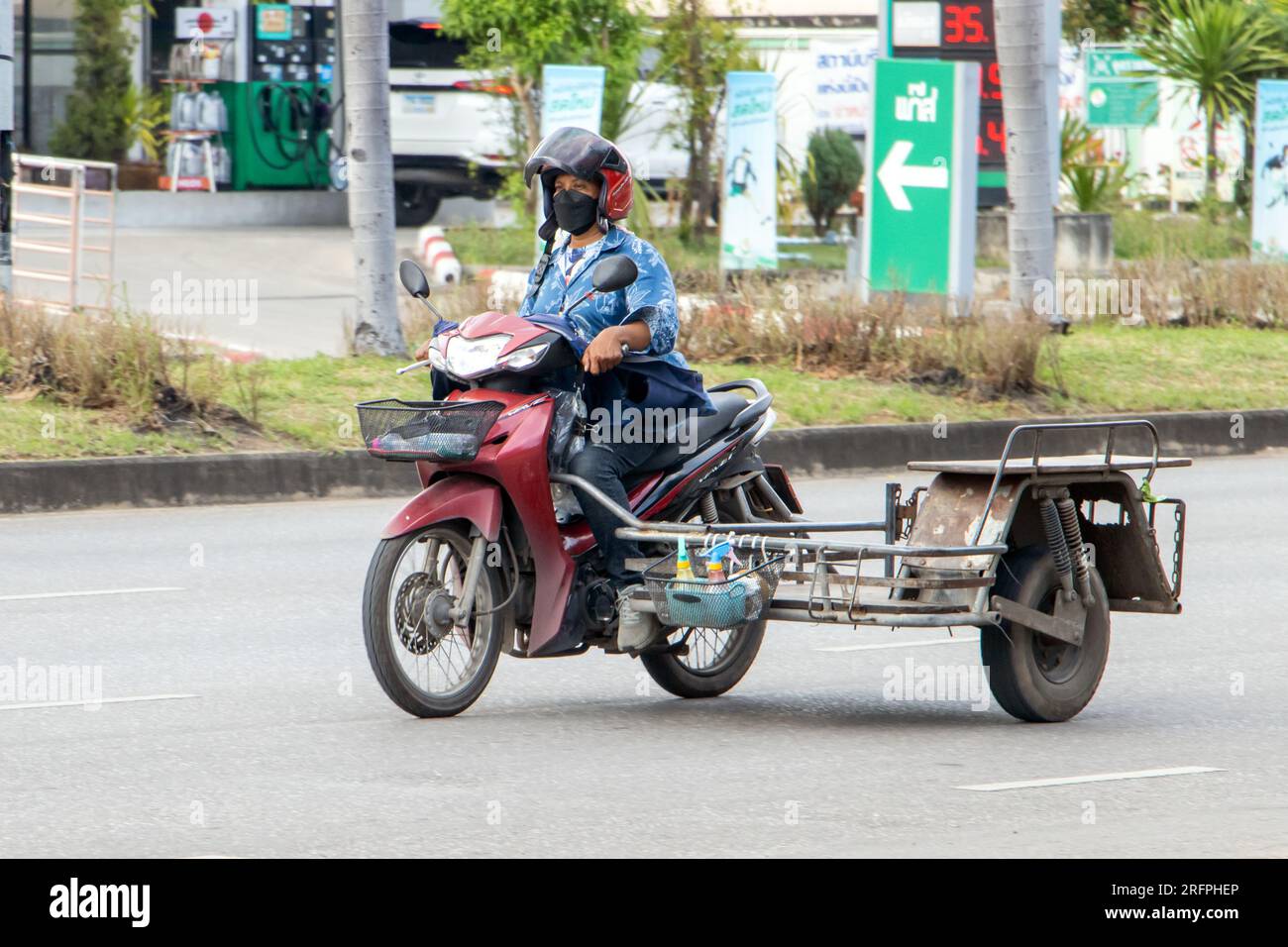 RATCHABURI, THAILAND, OCT 18 2022, A woman drives a motorcycle with a ...