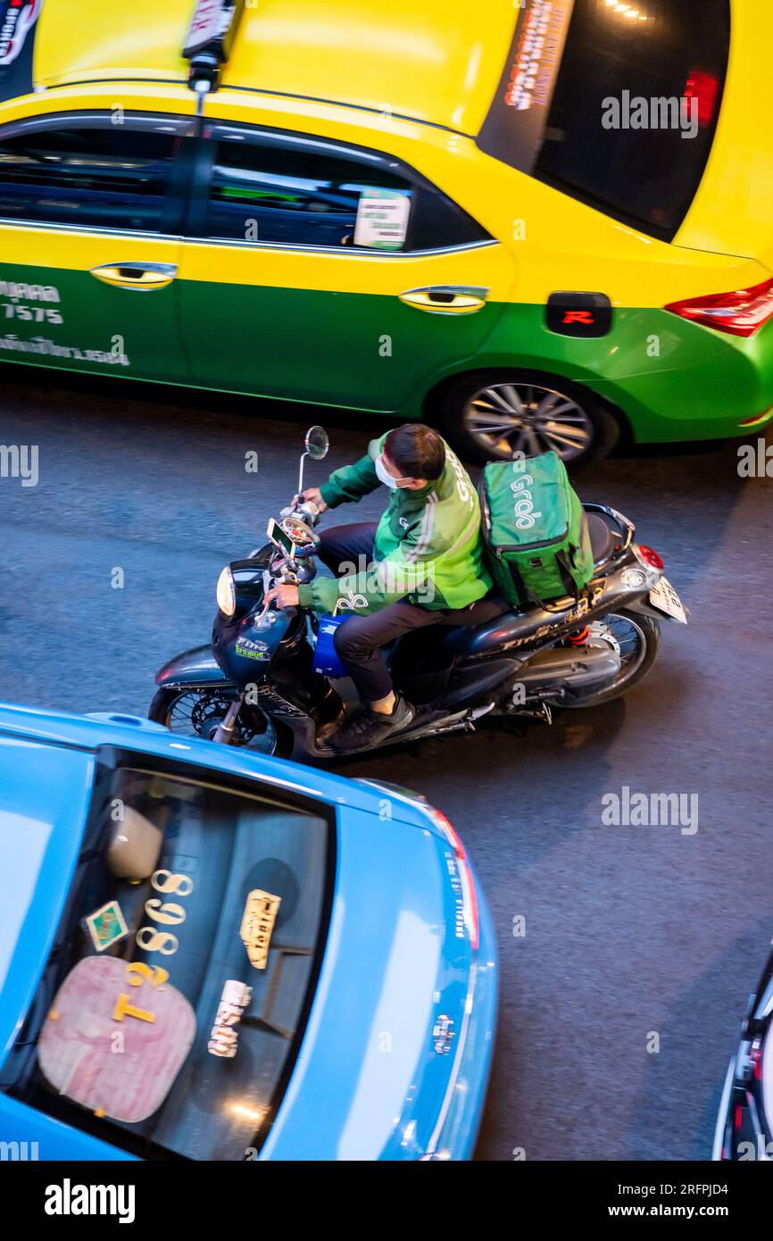 A Grab courier motorbike makes its way through the Bangkok city traffic ...