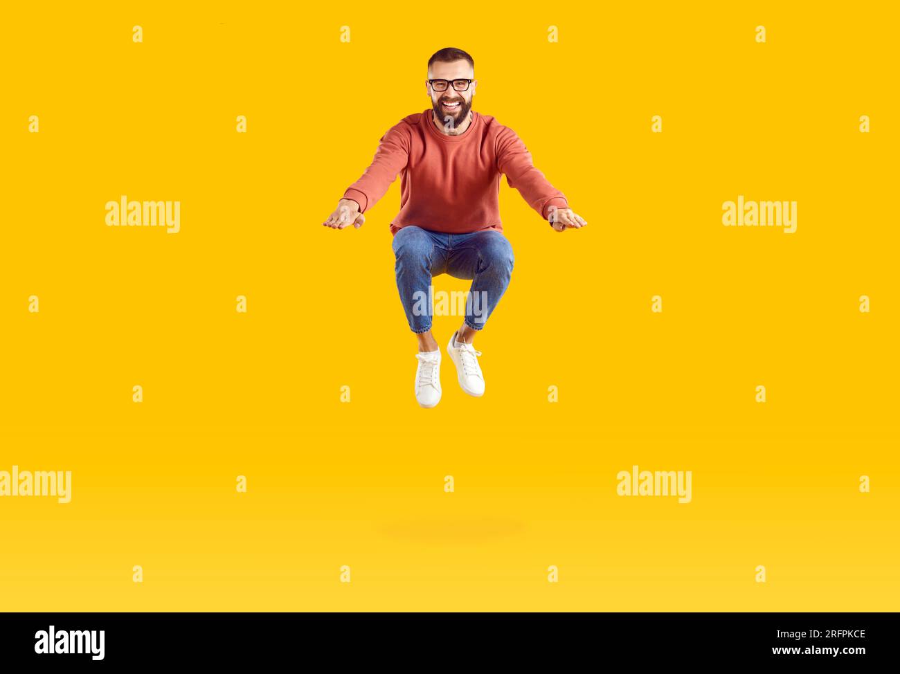 Happy excited man jumping in air on yellow background Stock Photo - Alamy