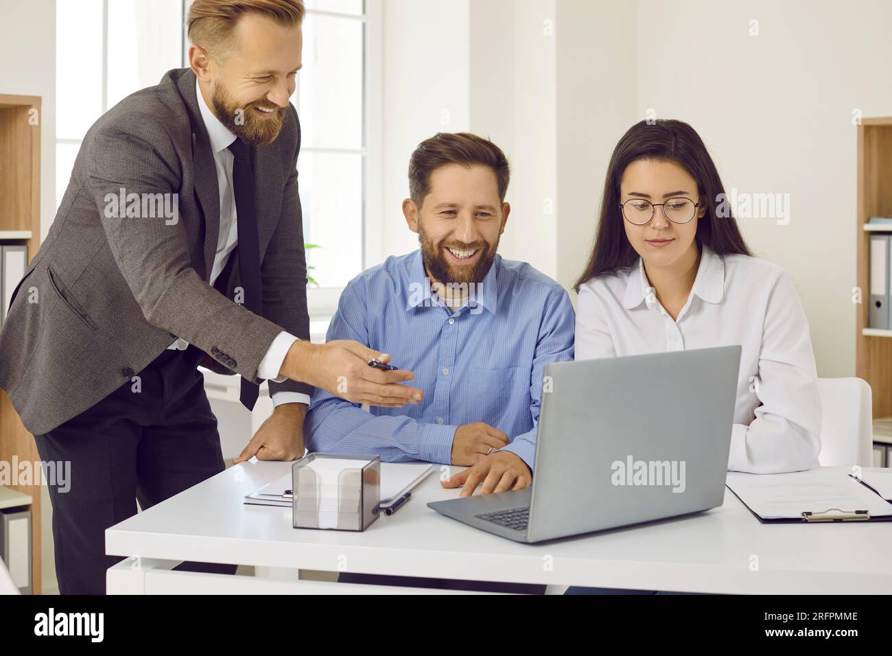 Happy, smiling real estate agent showing houses on his laptop computer ...