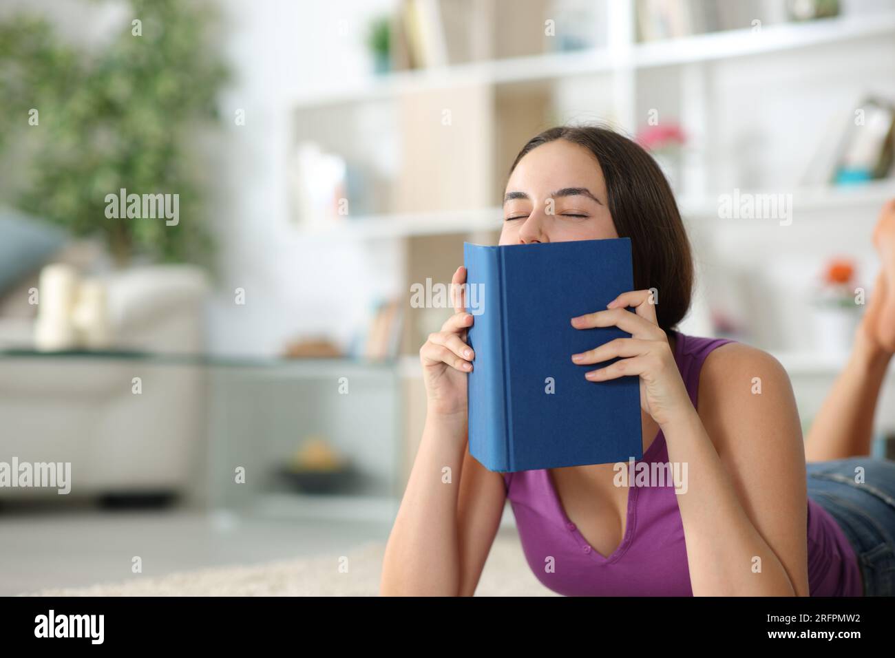 Reader smelling paper book lying on the floor at home Stock Photo - Alamy