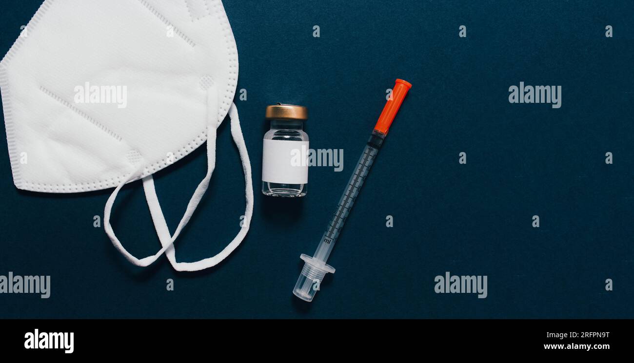 Web banner with vaccine in vial, syringe and face mask over dark blue ...