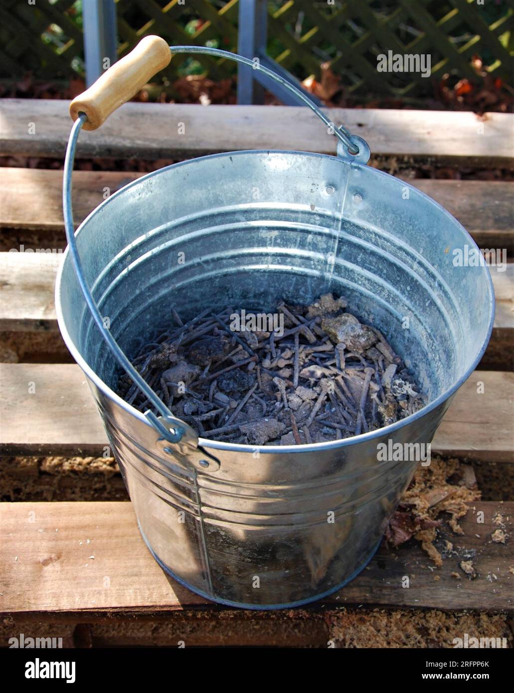 Steel bucket half full of rusty nails resting on a wooden pellet Stock ...