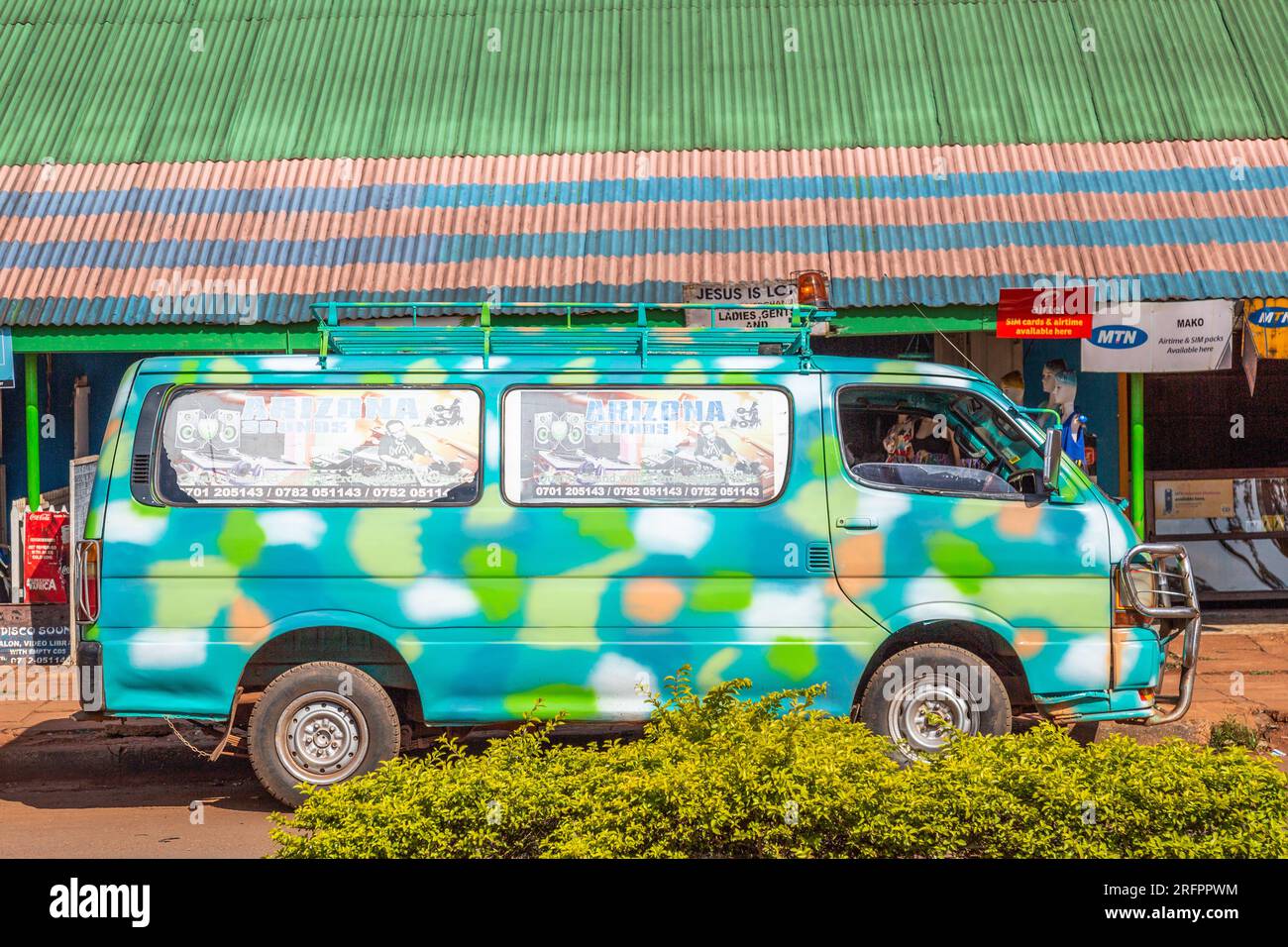 Turquoise van with multi-colored spots parked in front of a shopping ...
