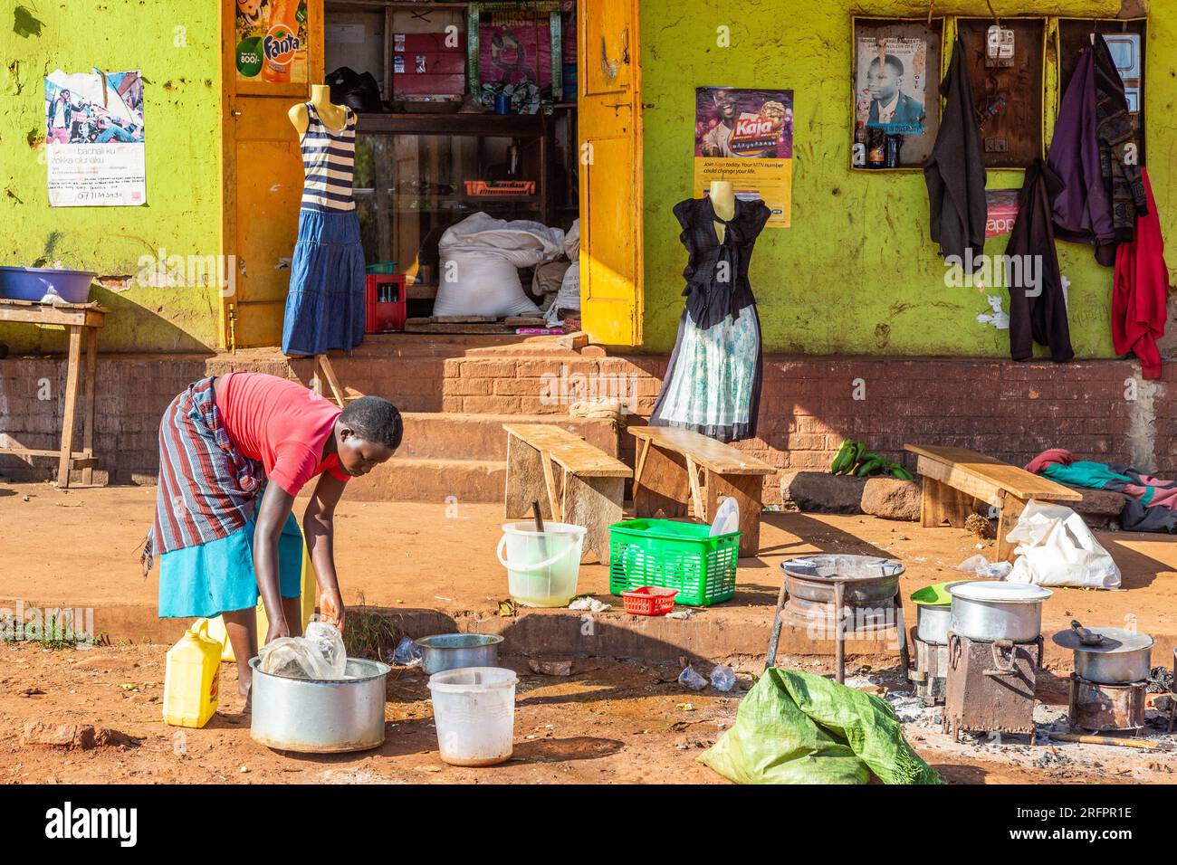 A housewife does laundry in the street, in front of a facade painted in ...