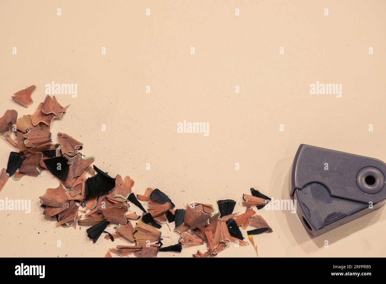 Pencil sharpener and a trail of pencil shavings isolated on a white ...