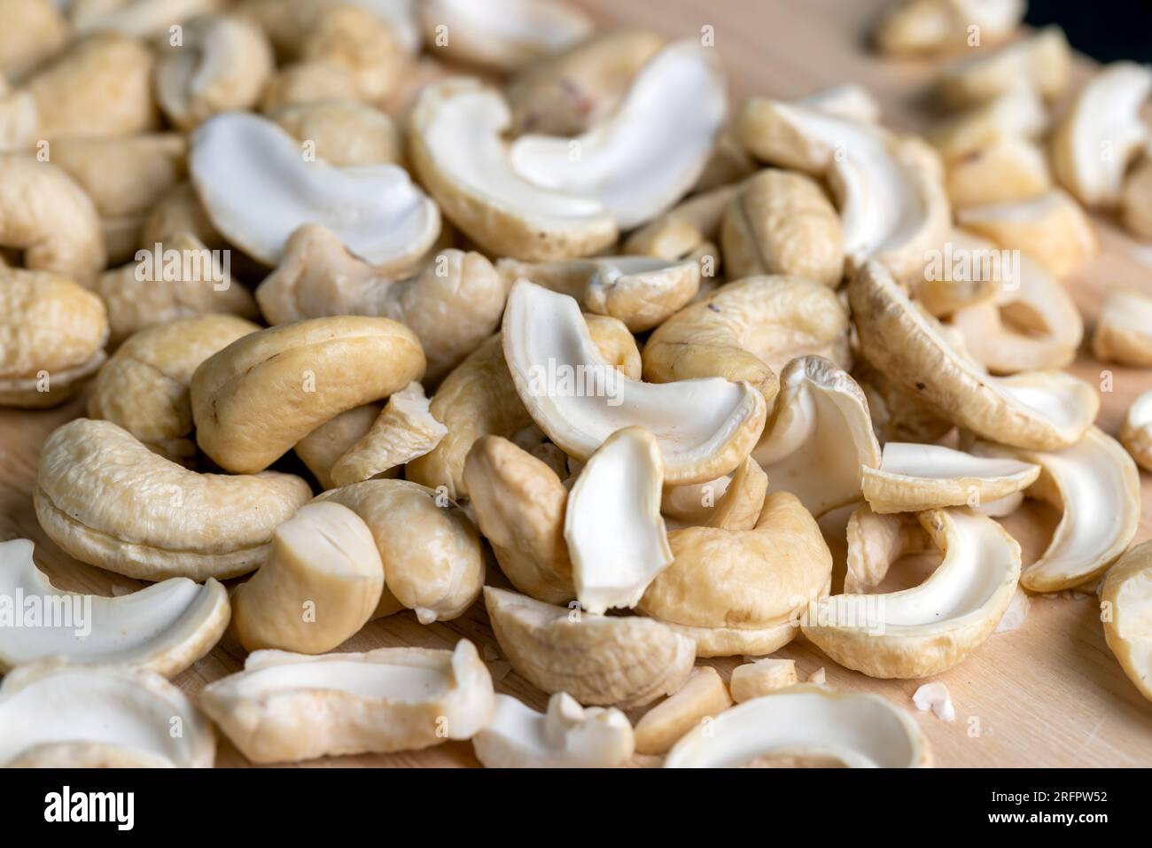 Delicious cashew nuts on a wooden surface, ready to eat and peeled ...