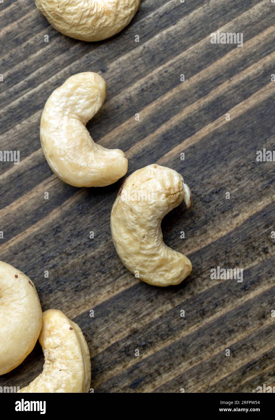 Delicious cashew nuts on a wooden surface, ready to eat and peeled ...