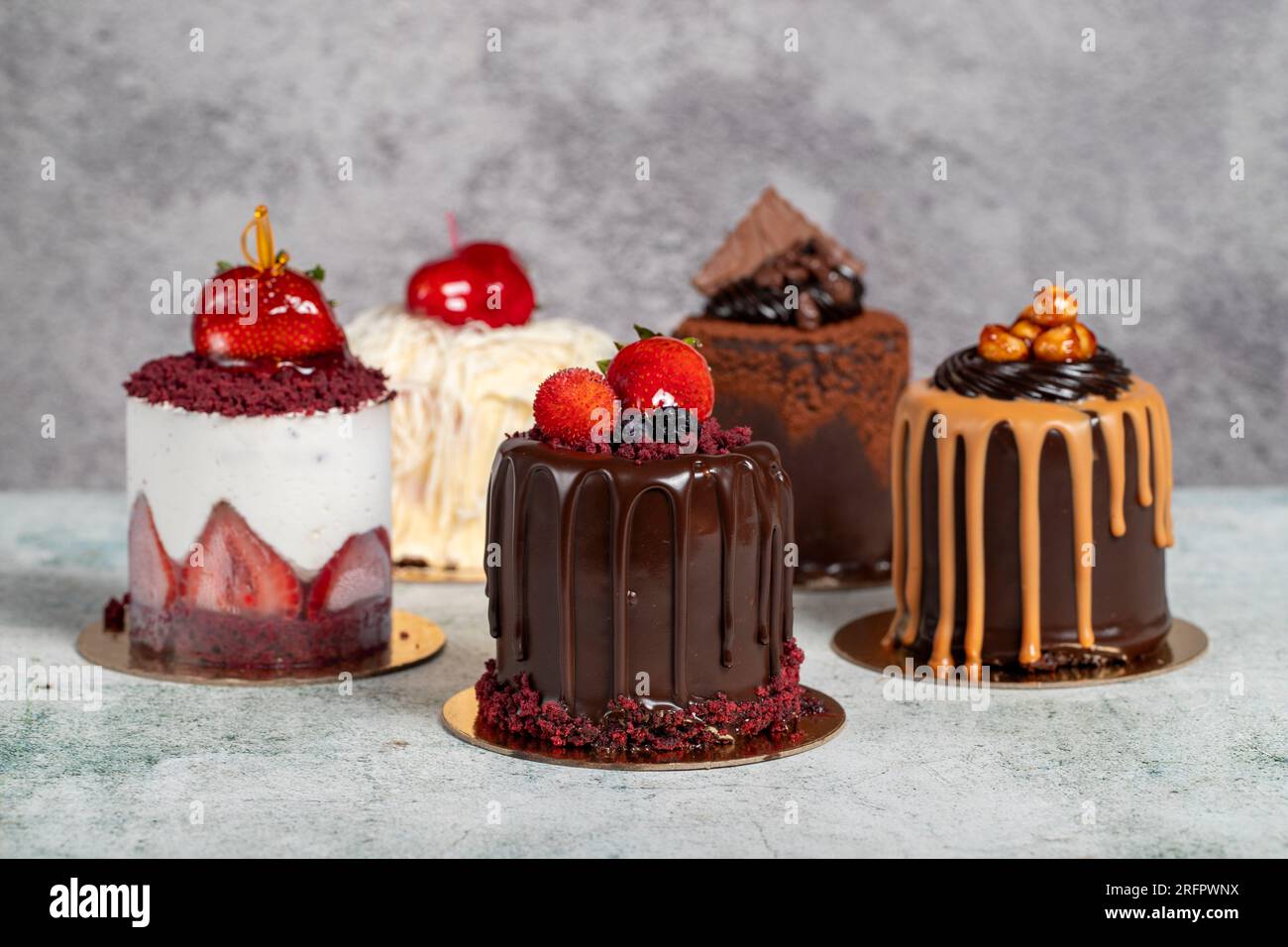 Types of cakes. Assortment of chocolate and fruit cakes on a gray ...