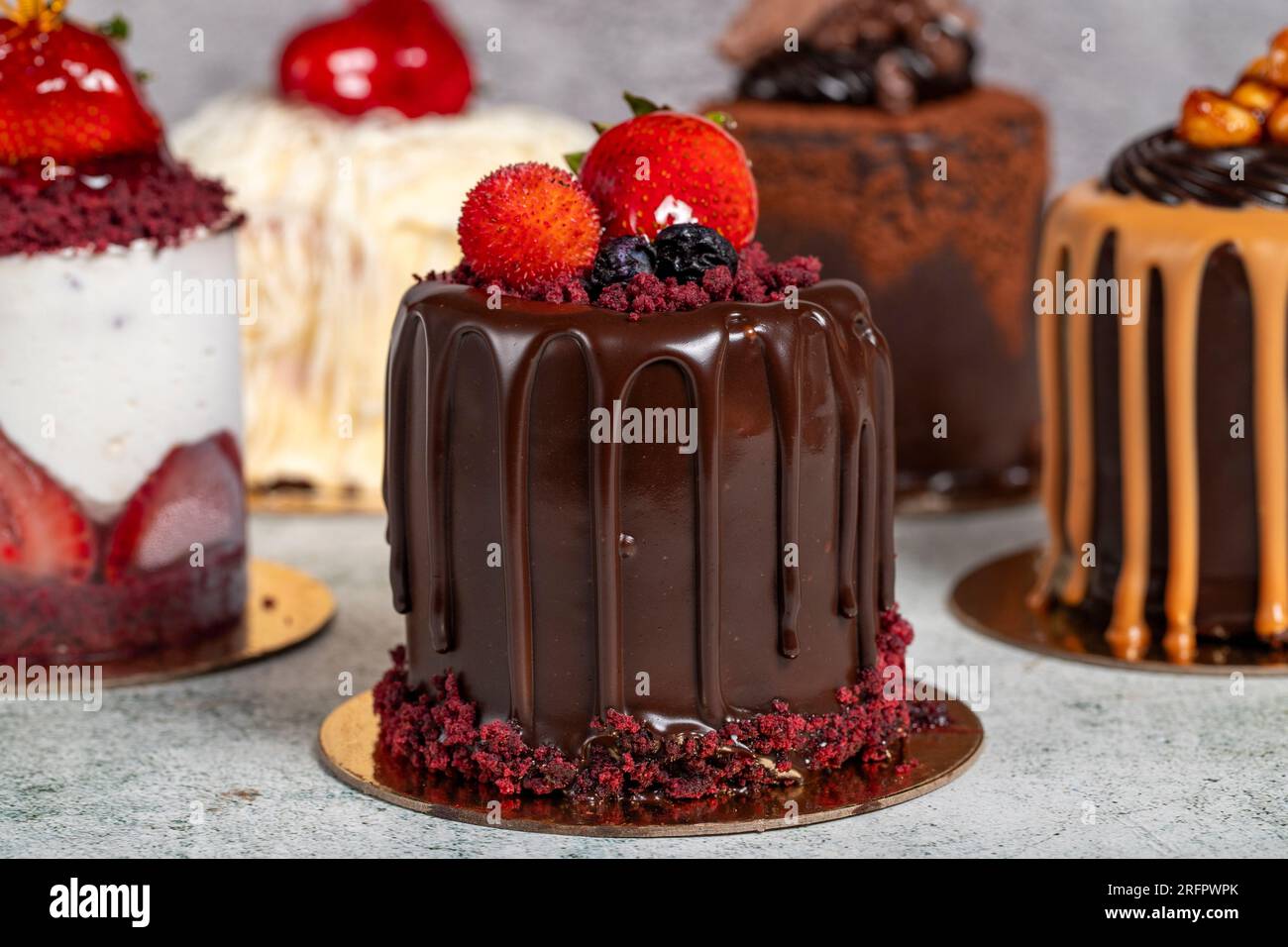 Types of cakes. Assortment of chocolate and fruit cakes on a gray ...