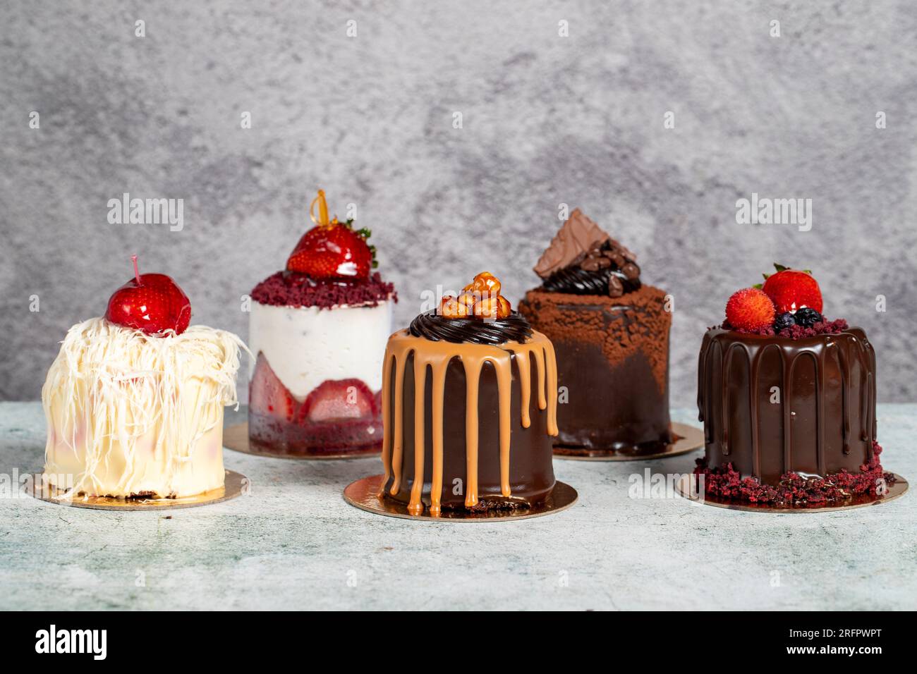 Types of cakes. Assortment of chocolate and fruit cakes on a gray ...