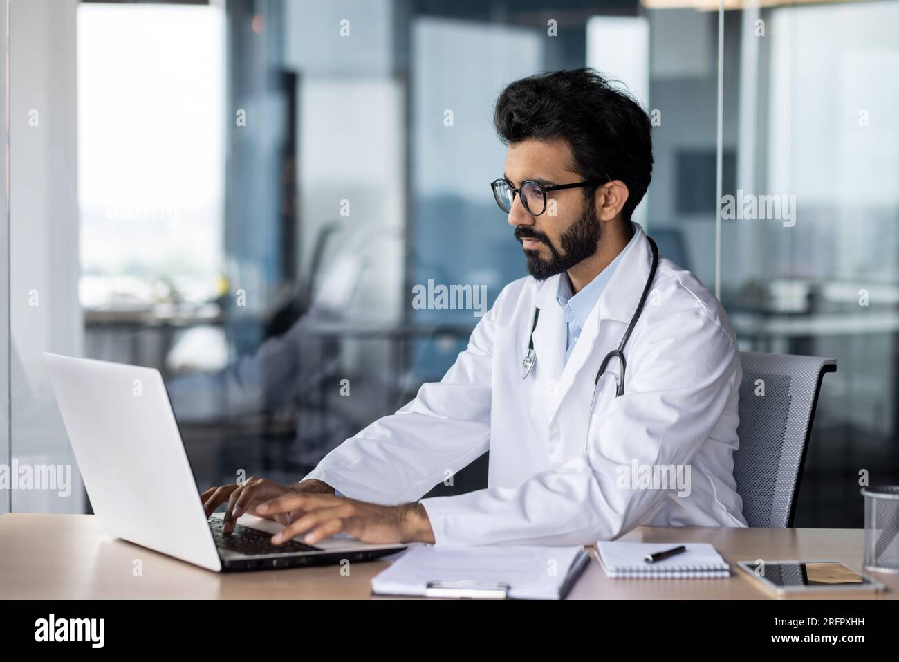 Concentrated and serious indian male doctor student studying online in ...