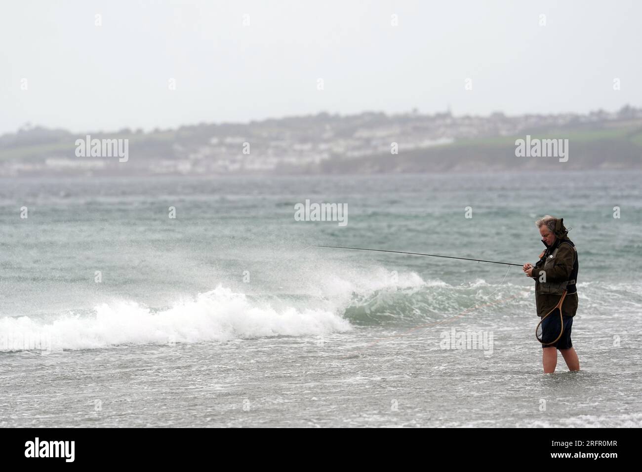 A fisherman on Carne beach in Cornwall, as a danger to life warning has ...