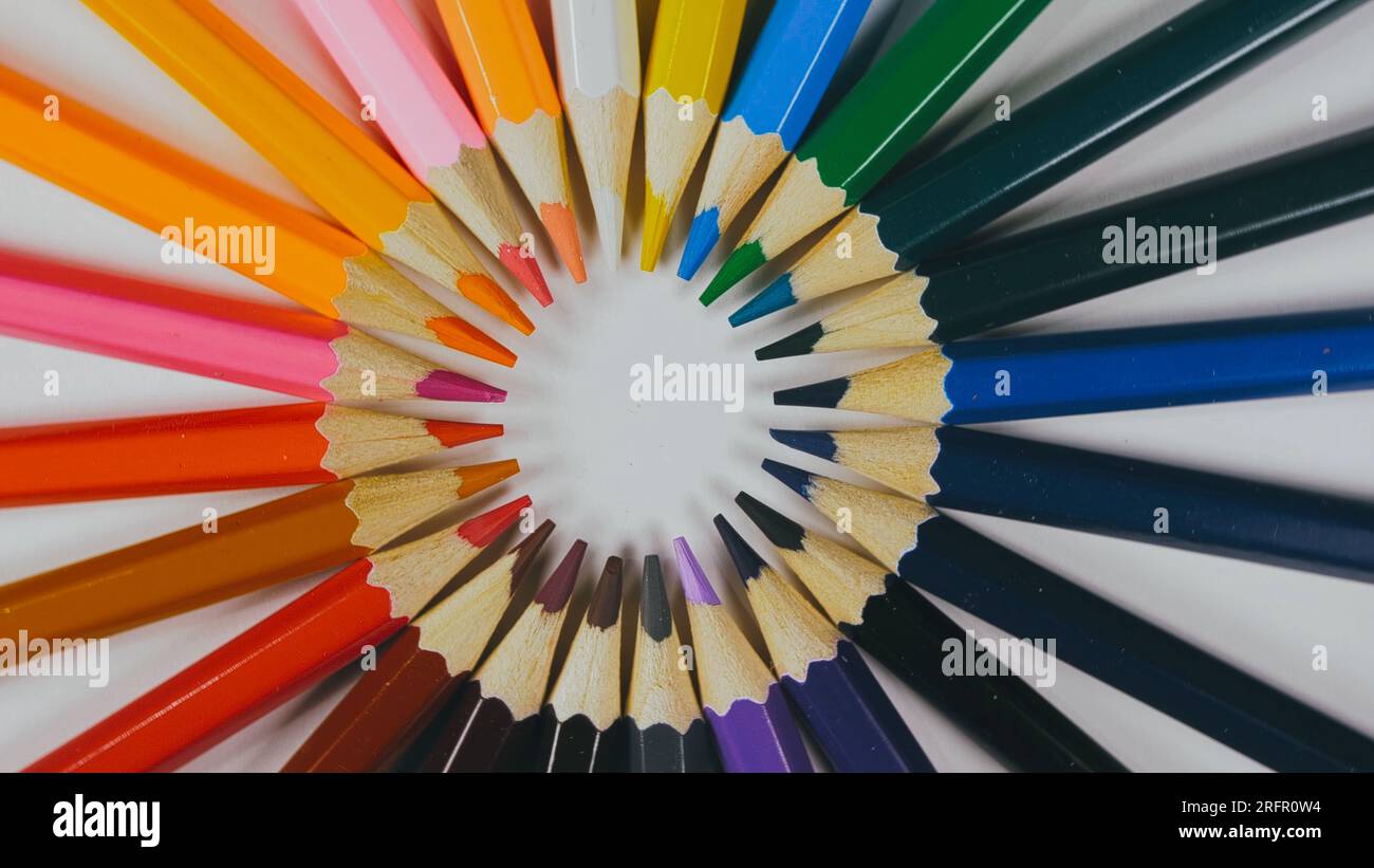 Many colored pencils are arranged around the edges of the image as a ...