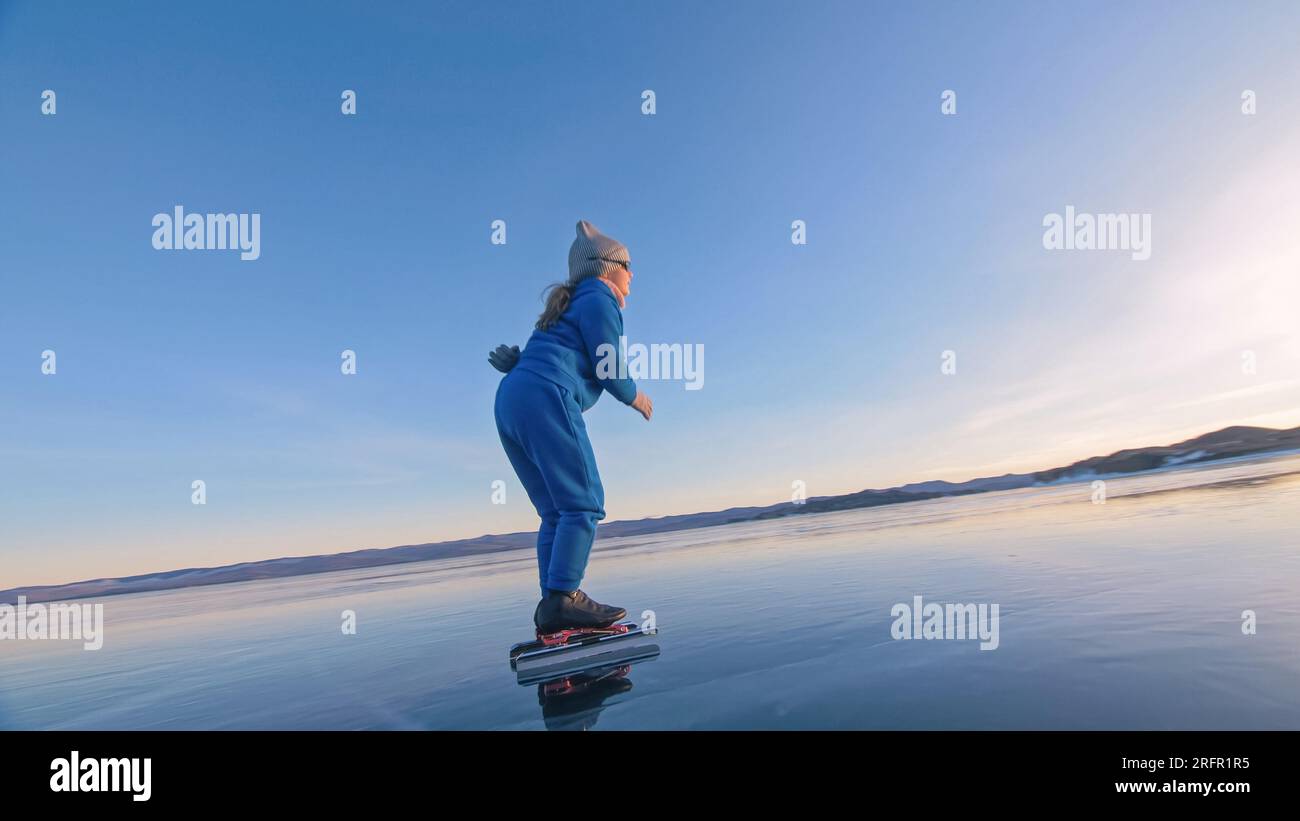 The child train on ice professional speed skating. The girl skates in ...
