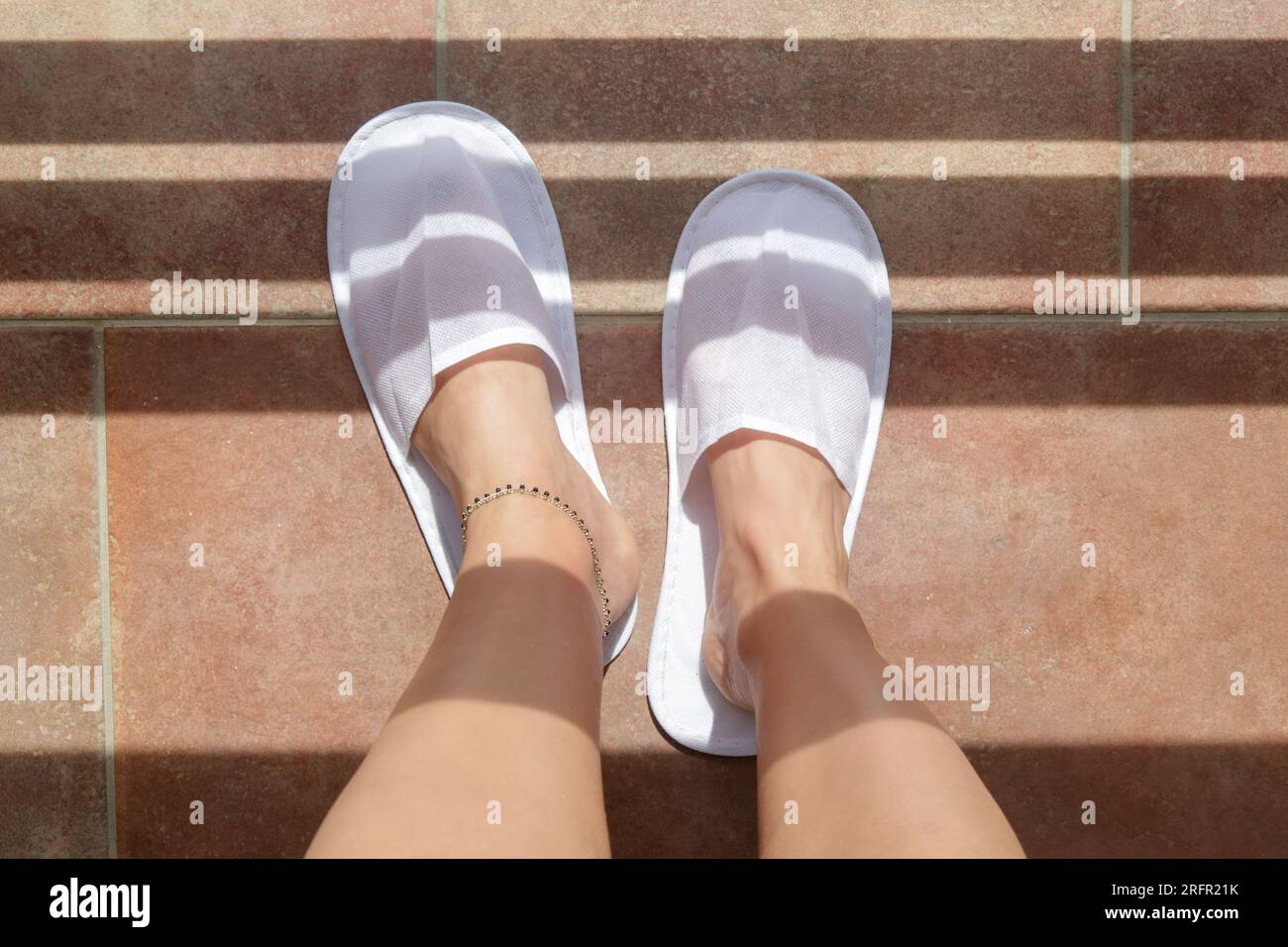 Feet in white hotel slippers on balcony Stock Photo - Alamy