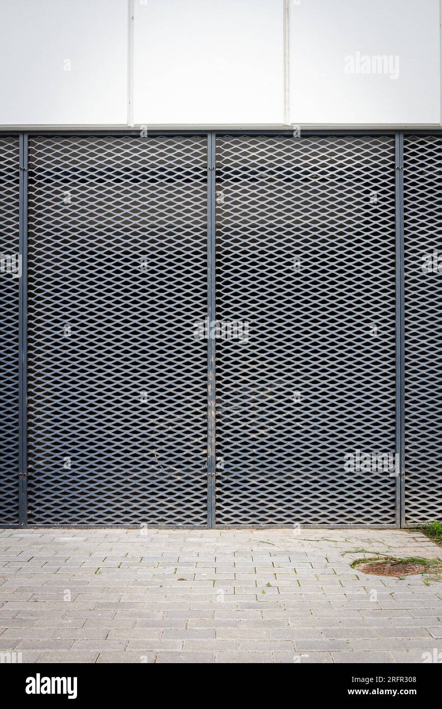 Iron grid wall and a sidewalk. Architecture detail background Stock ...