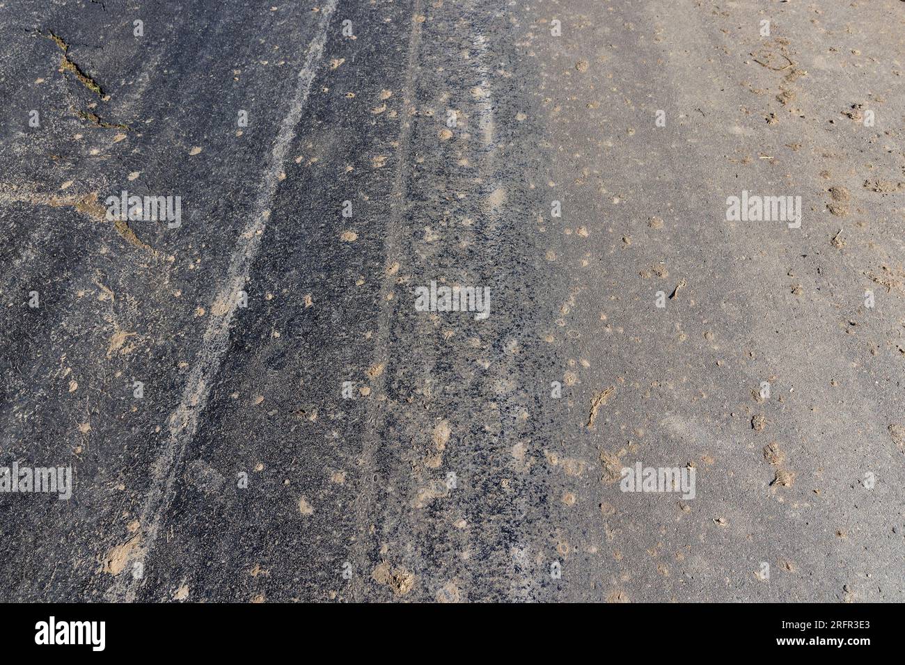 Details of a road polluted with sand and debris from fields, sand and ...