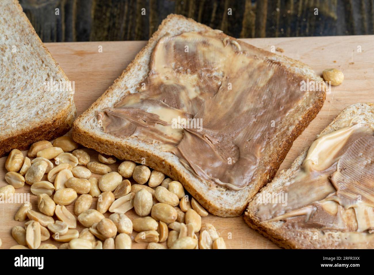 Peanut paste with chocolate paste on white bread, making sandwiches ...