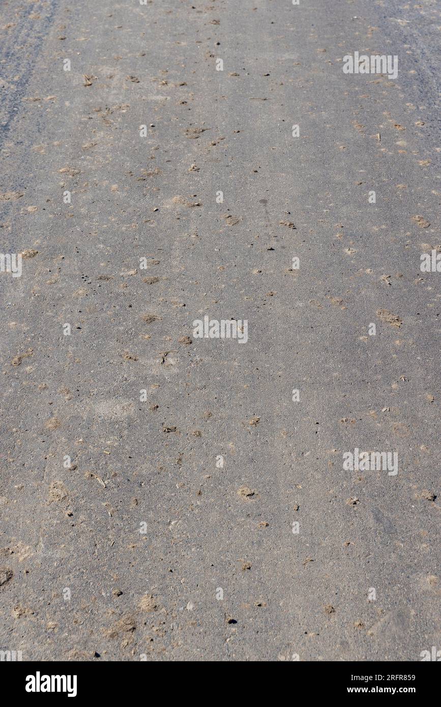 Details of a road polluted with sand and debris from fields, sand and ...