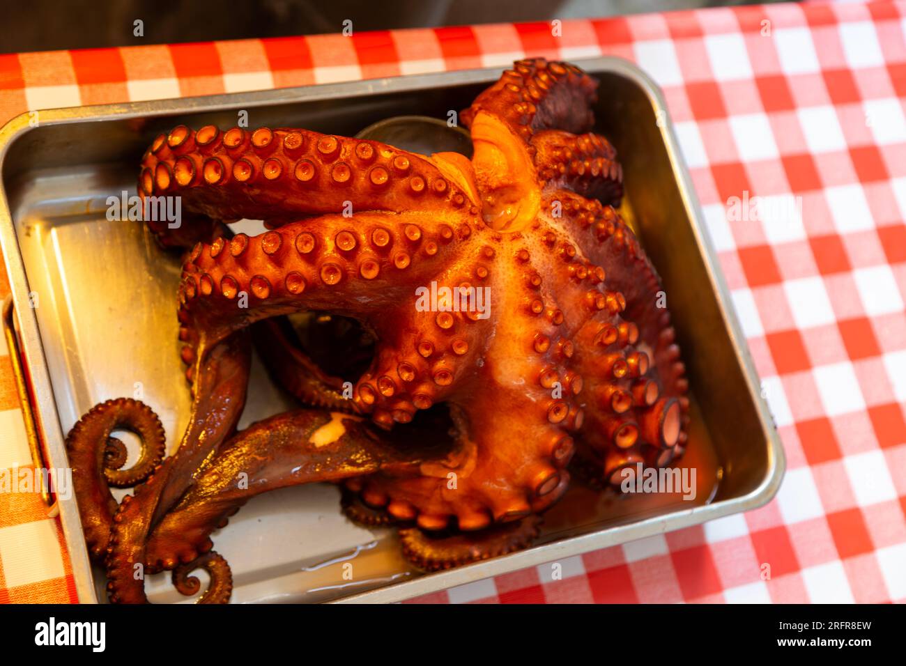 Cooked octopus on display on restaurant table with red and white ...