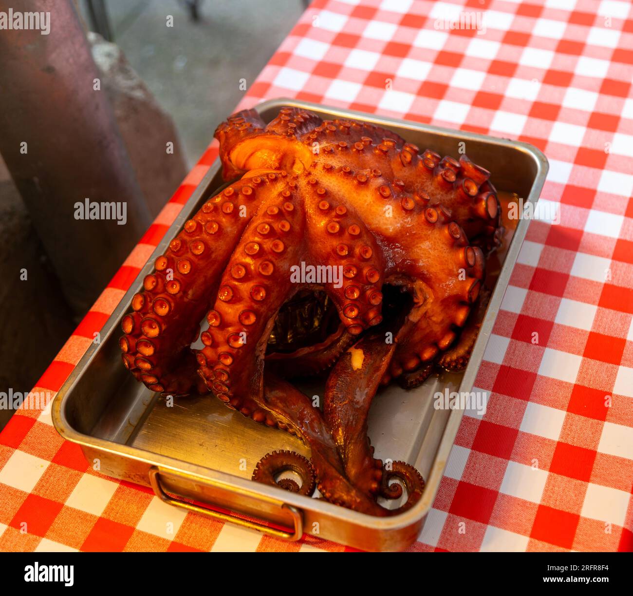 Cooked octopus on display on restaurant table with red and white ...