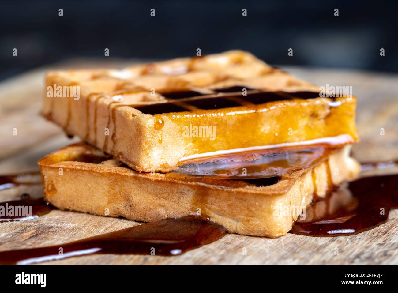 square sweet soft waffles in bee honey , a traditional European dessert ...