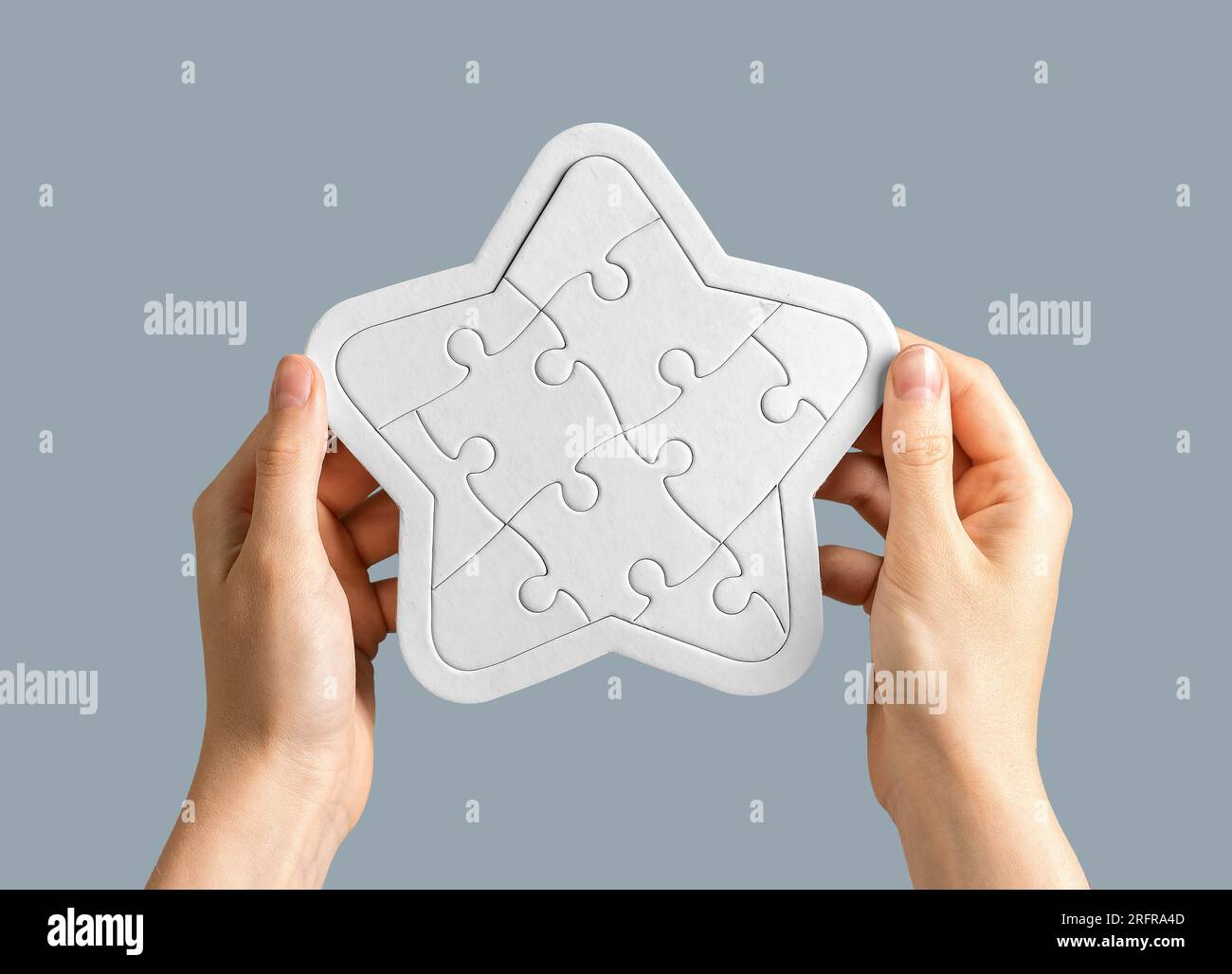 Hands holding star puzzle, joined together, solved. Opinion, rating ...