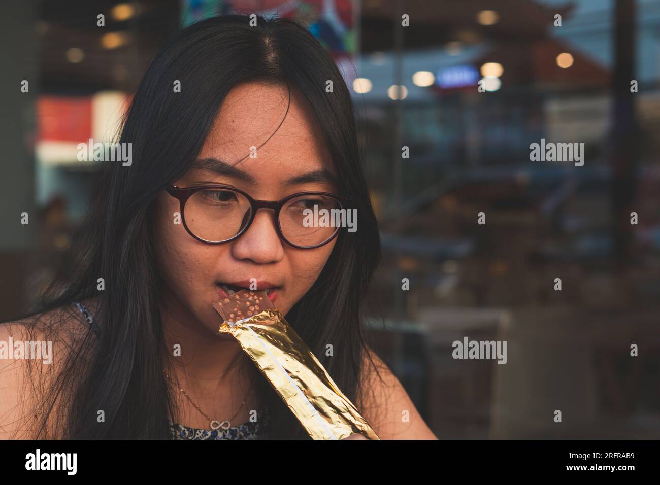 Close up young happy woman biting chocolate bar. People lifestyle food ...