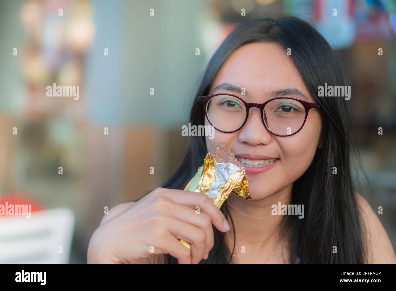 Close up young happy woman biting chocolate bar. People lifestyle food ...