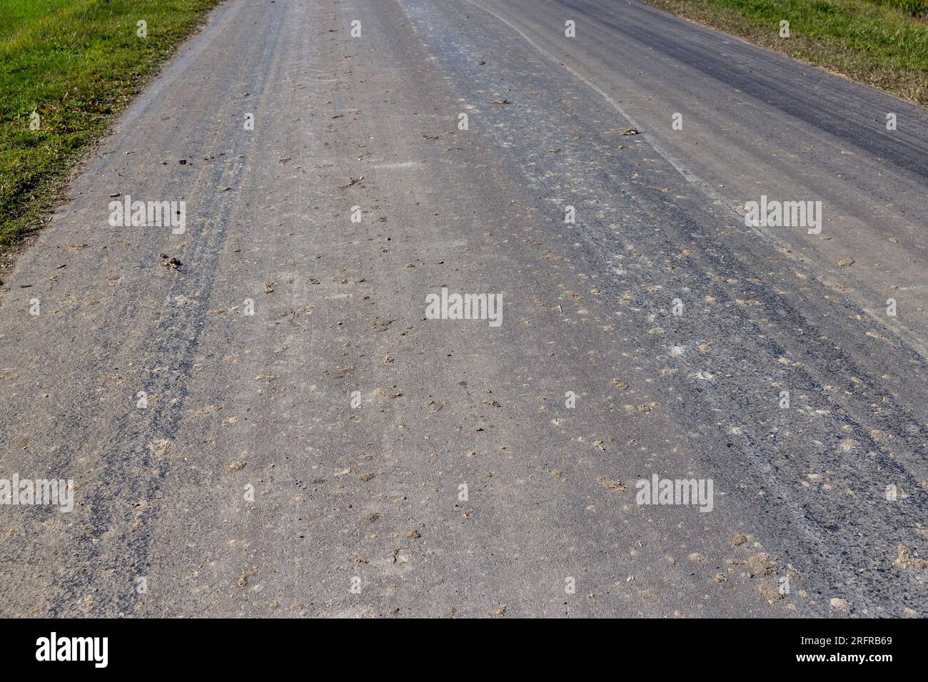 Details of a road polluted with sand and debris from fields, sand and ...