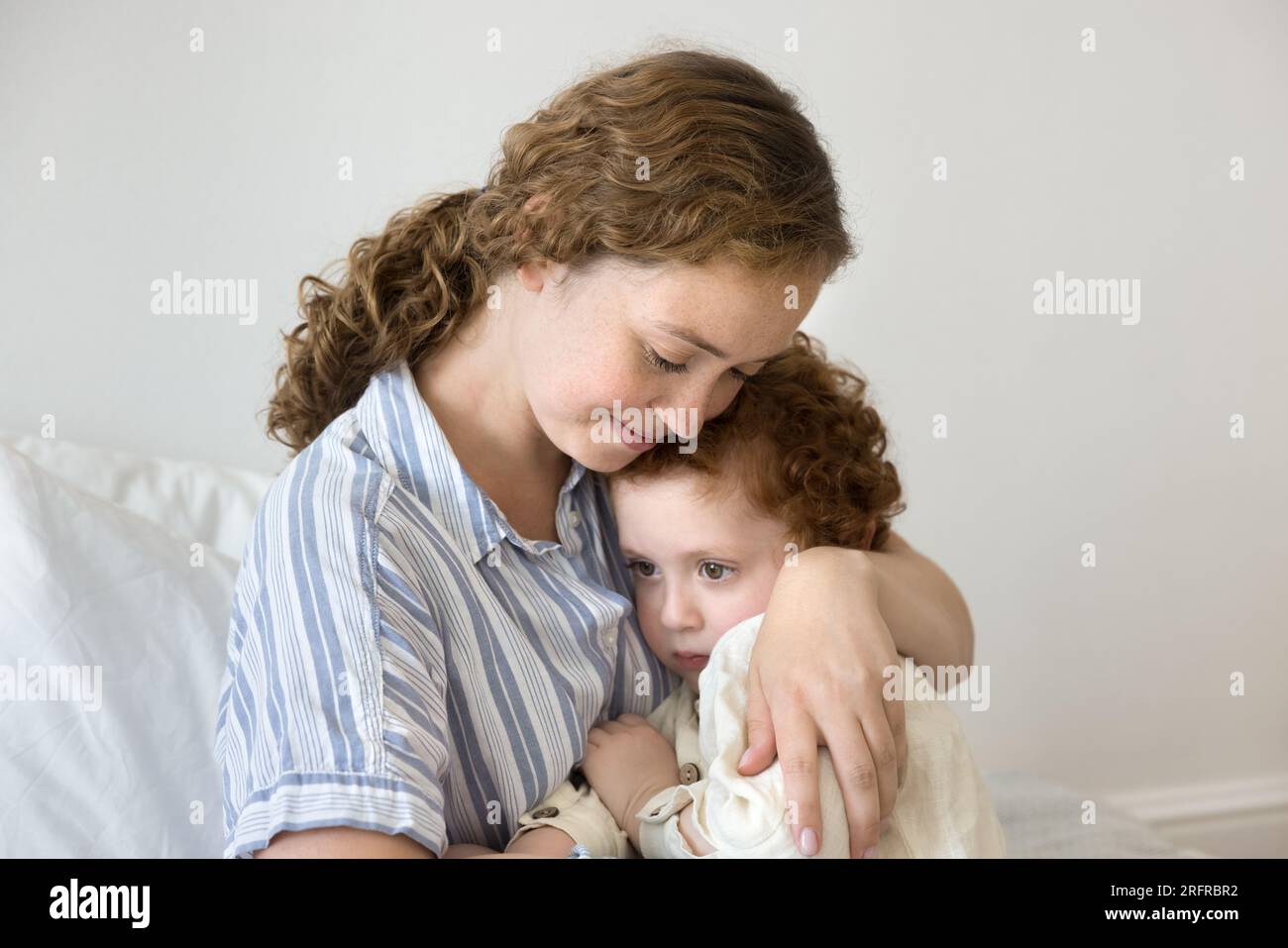 Positive pretty young mother comforting upset offended toddler kid ...
