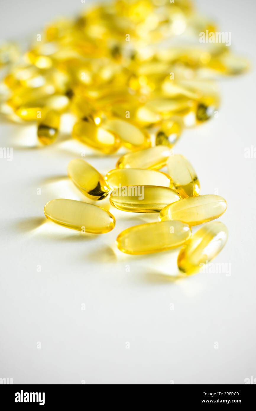 Fish oil supplement capsules on a white surface as a background. Oil ...
