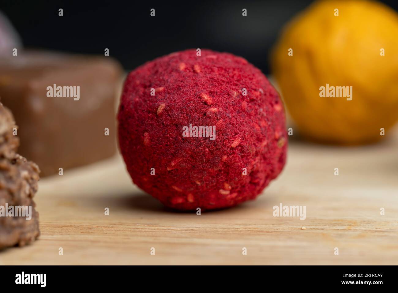 Red sweet candy in the shape of a ball on the table, chocolate candy ...