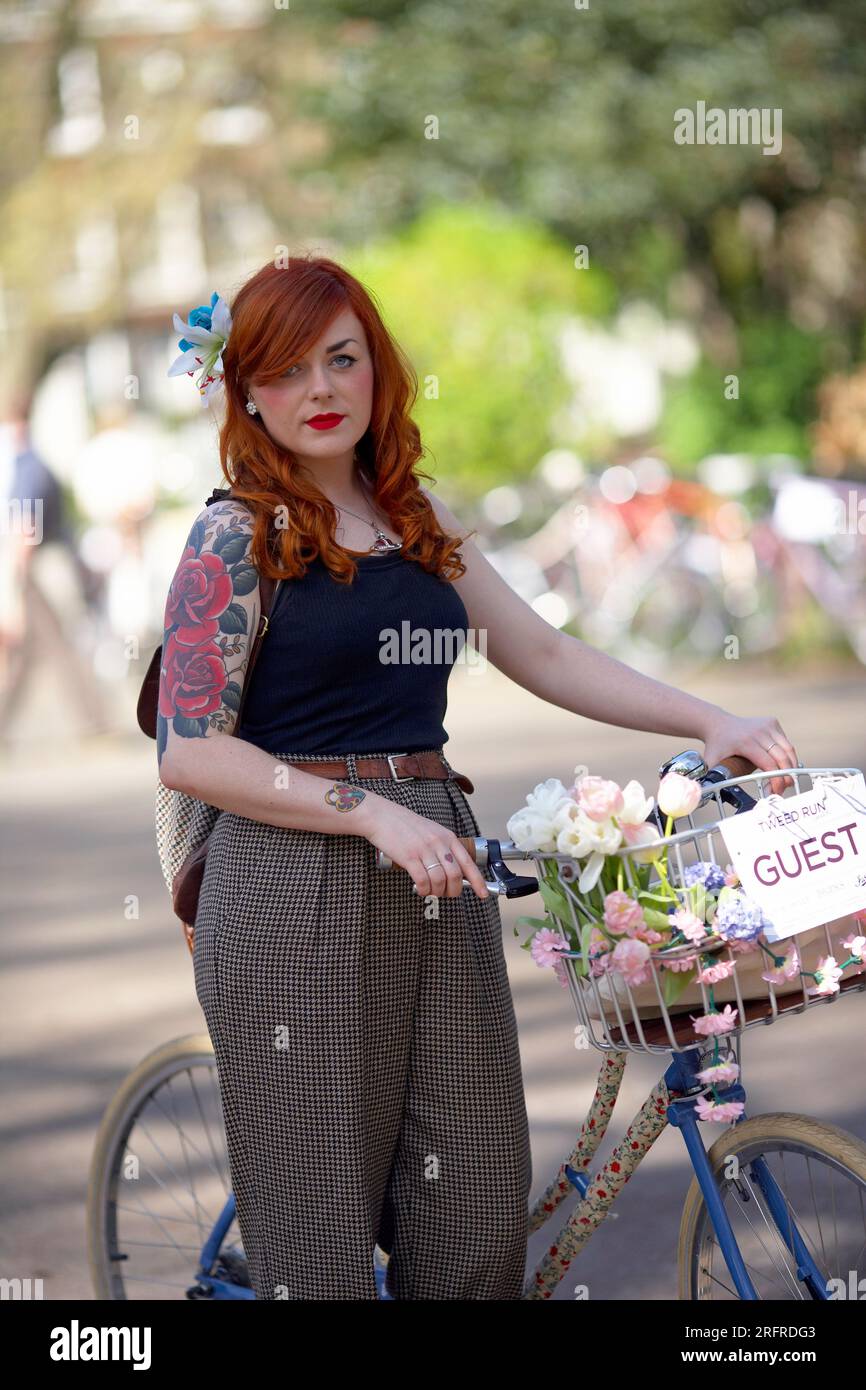 Young female Tweed Run participant with retro bike and tattoo, London ...