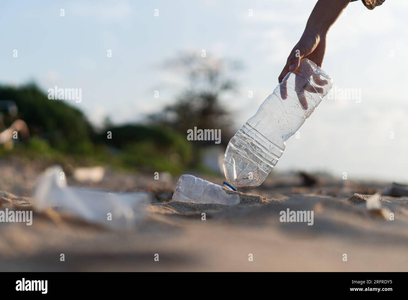 Volunteer picking plastic bottle clean up day, collecting waste on sea ...