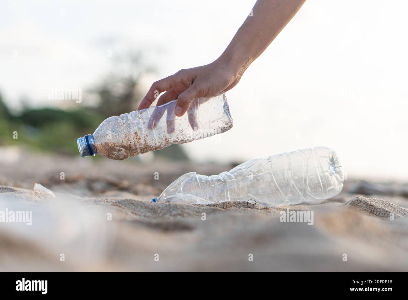 Volunteer picking plastic bottle clean up day, collecting waste on sea ...