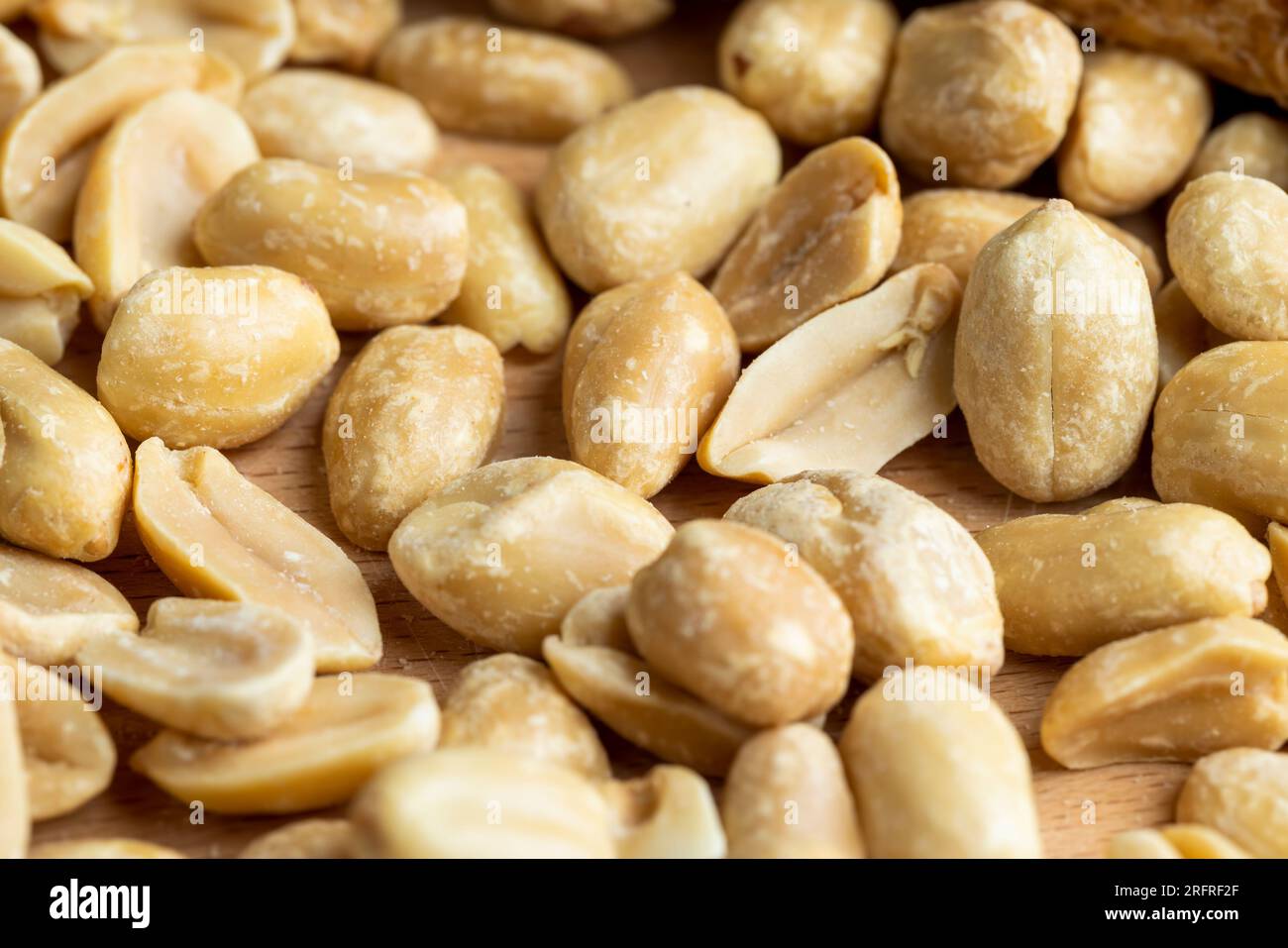 Peeled and roasted peanuts on the table, a pile of whole and half ...