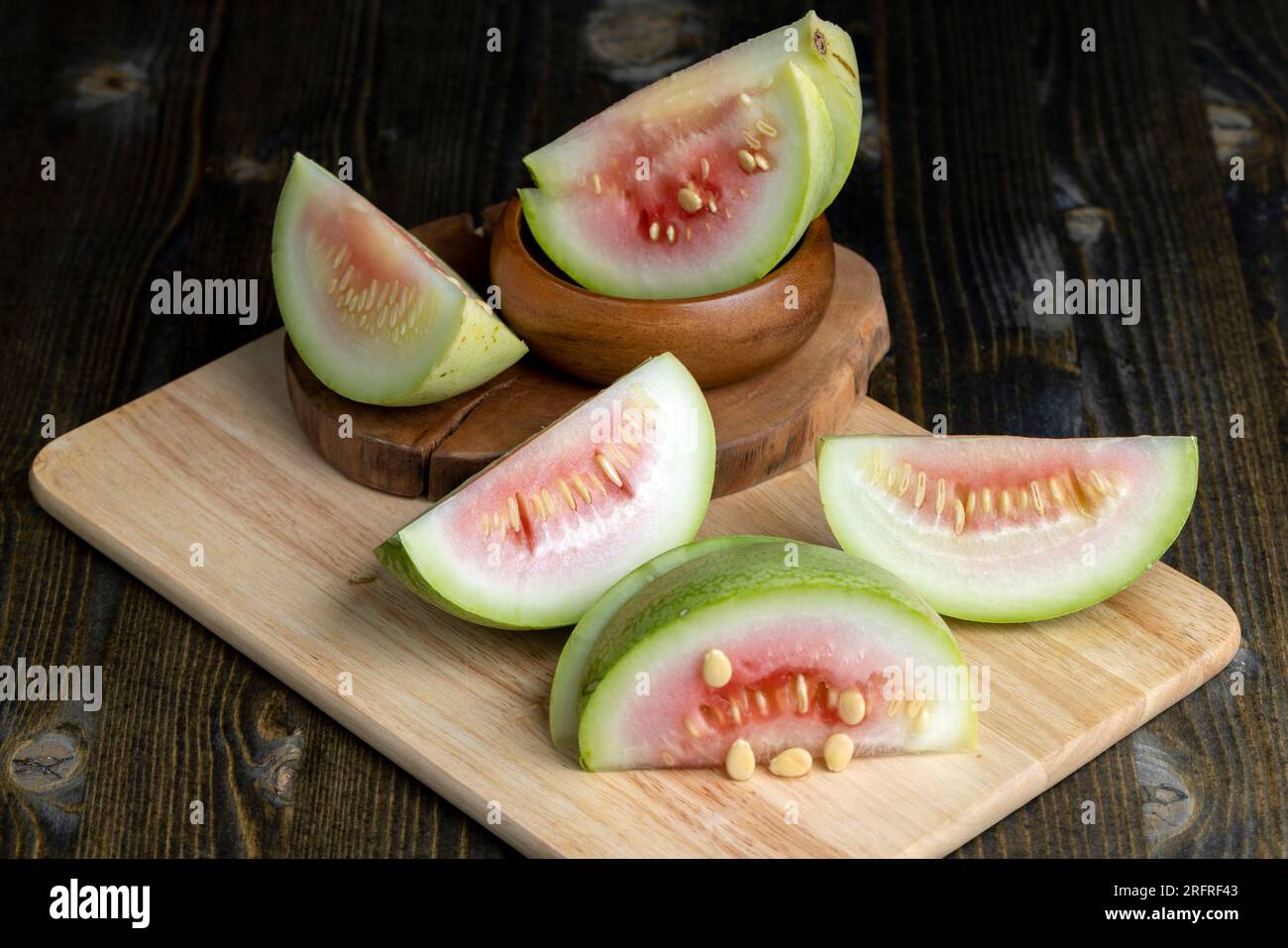 cut small unripe watermelon on a board, cut into pieces unripe ...