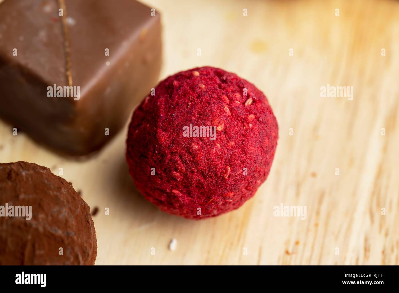 Red sweet candy in the shape of a ball on the table, chocolate candy ...
