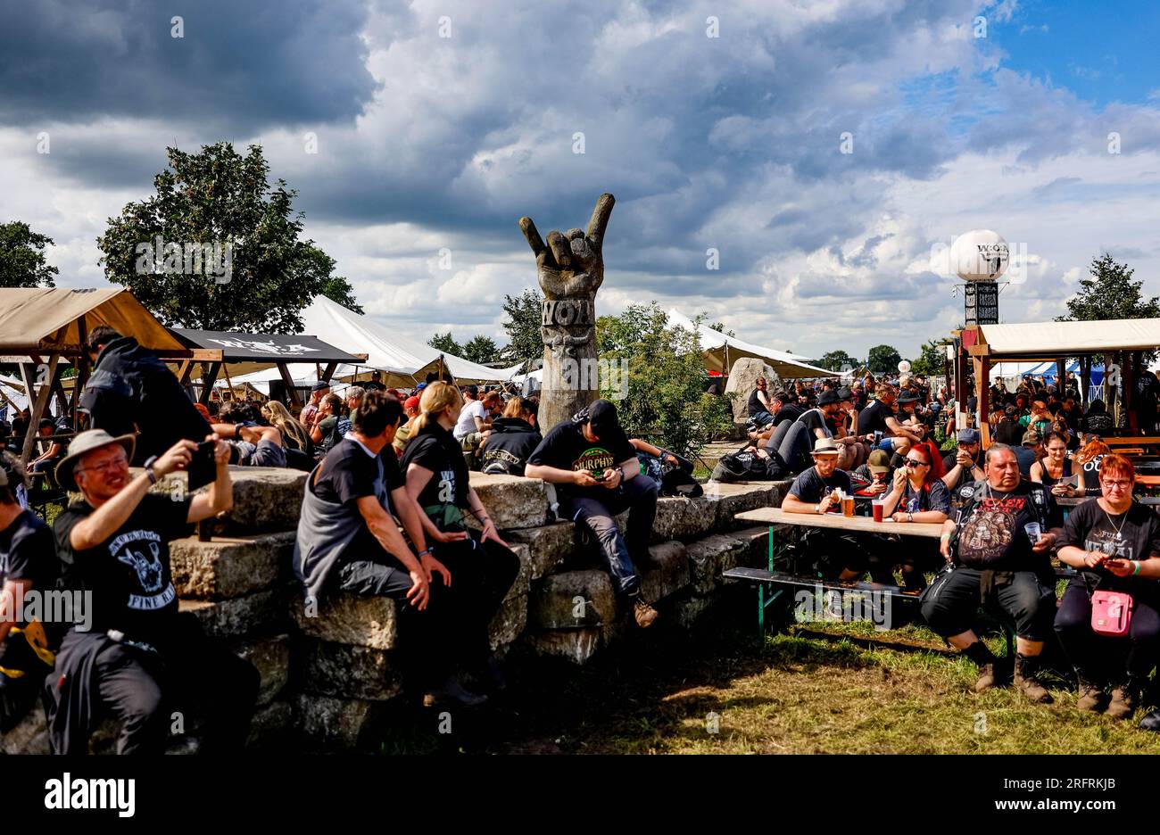 Wacken, Germany. 05th Aug, 2023. Visitors of the Wacken Open Air sit in ...