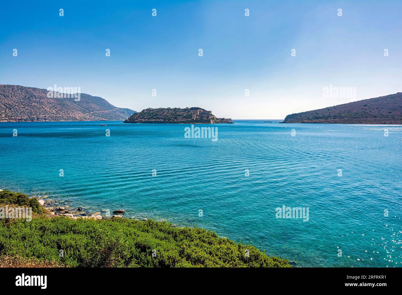 Panoramic view of the island of Spinalonga with calm sea. Here were ...