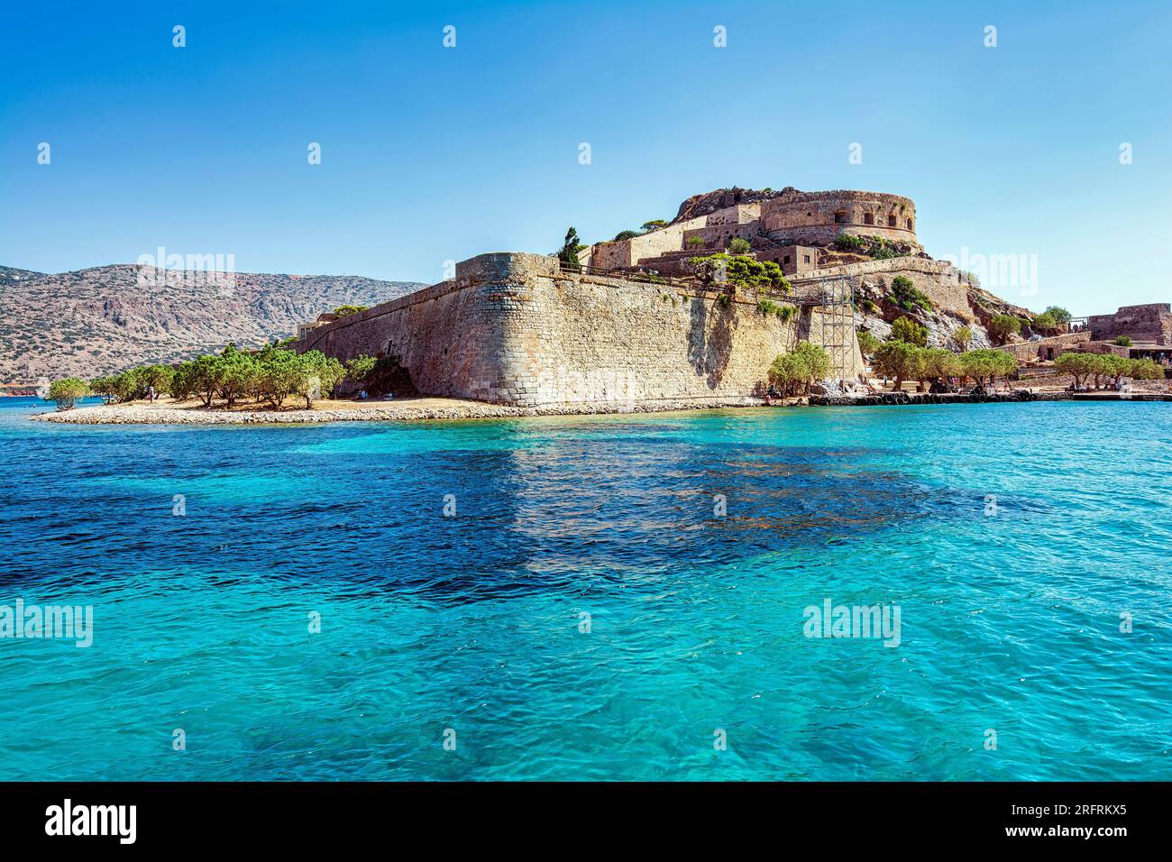 Panoramic view of the island of Spinalonga with calm sea. Here were ...