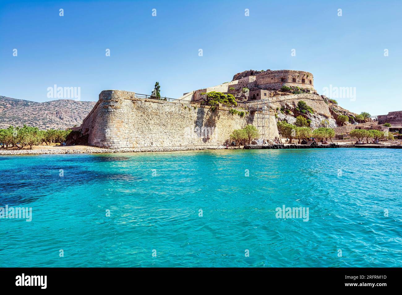 Panoramic view of the island of Spinalonga with calm sea. Here were ...